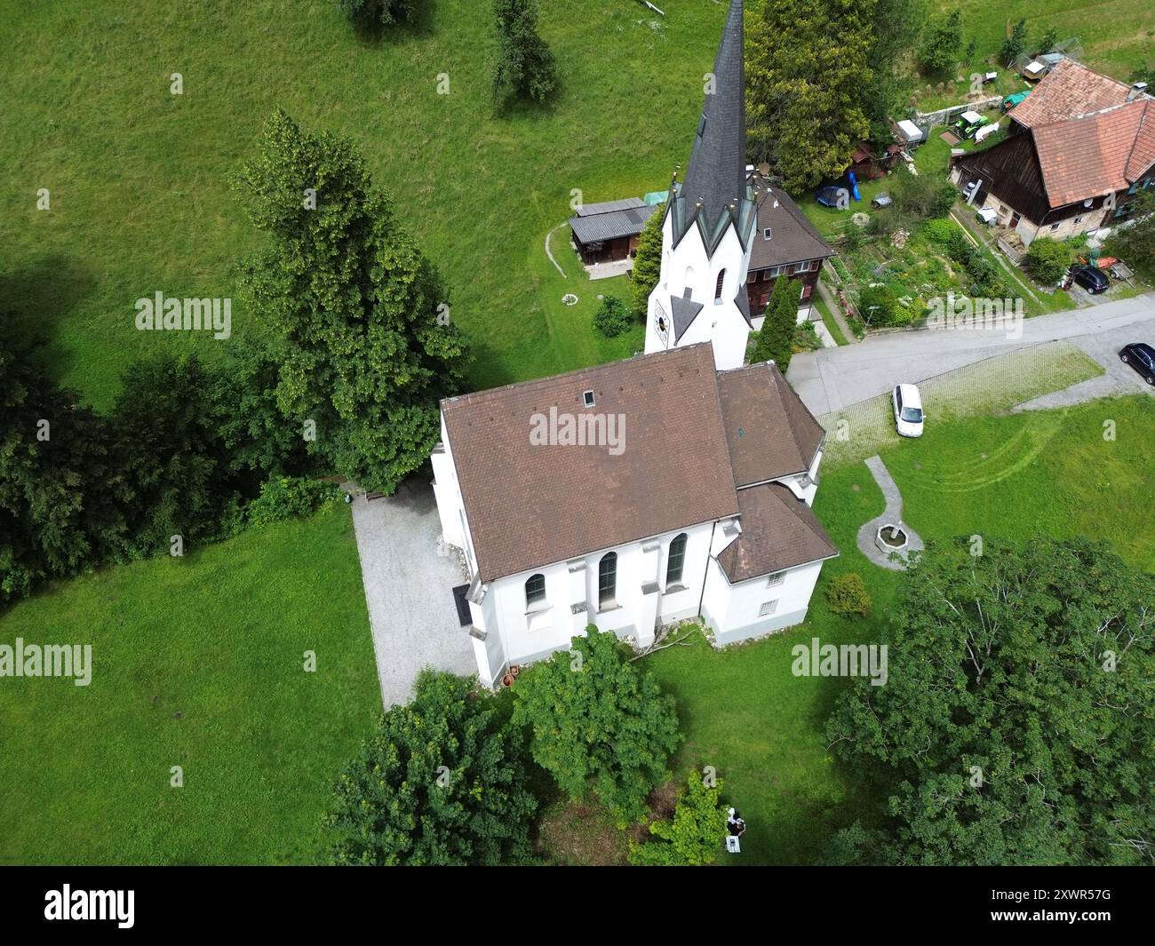 An aerial view of Kuratienkirche Meschach surrounded by lush greenery ...