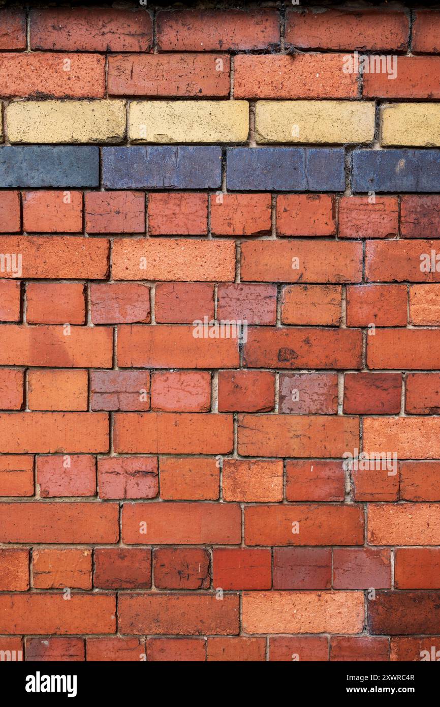 Colorful brick wall with varying shades of red, orange, yellow, and ...