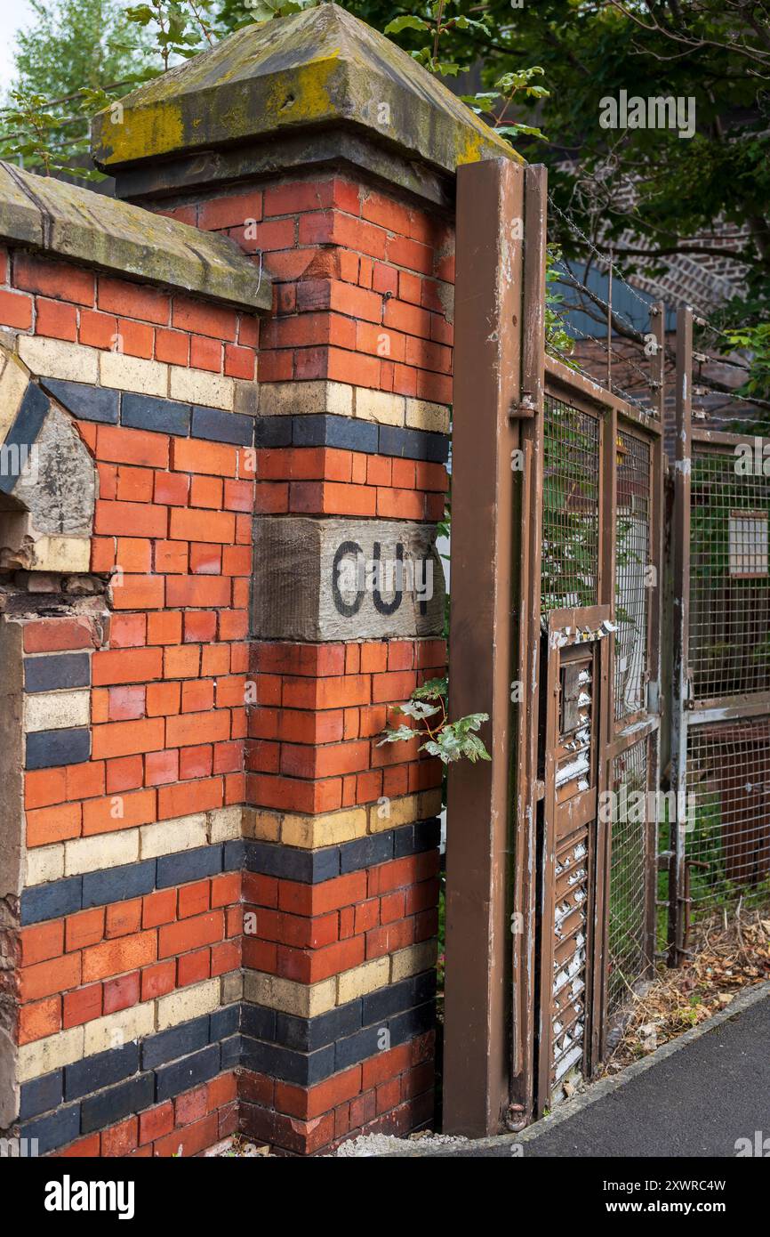 Vintage red brick wall with weathered stone accents and a rusting metal ...