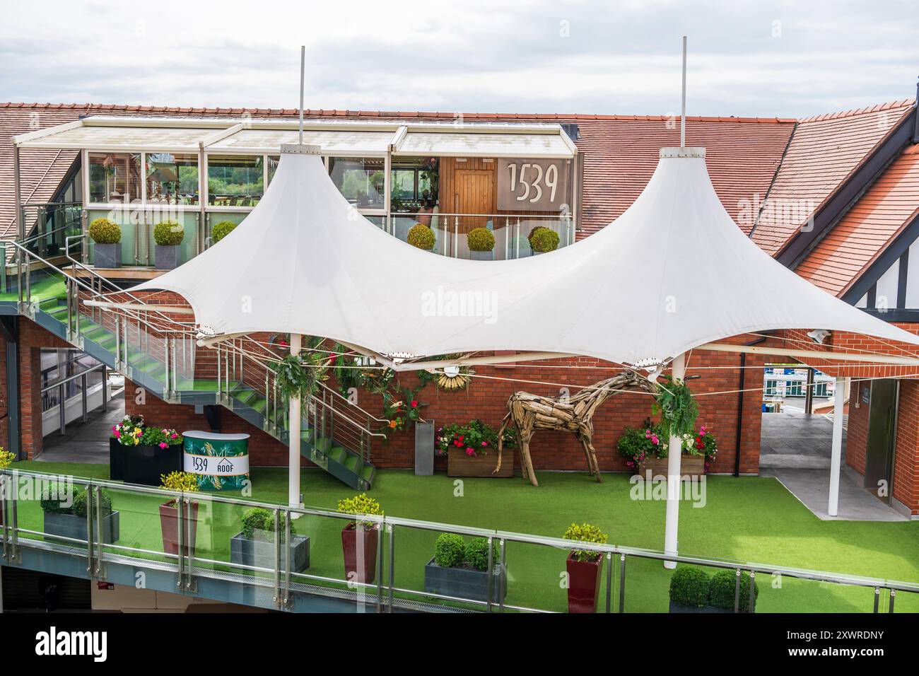 Modern outdoor seating area with canopy and greenery at a stylish venue ...