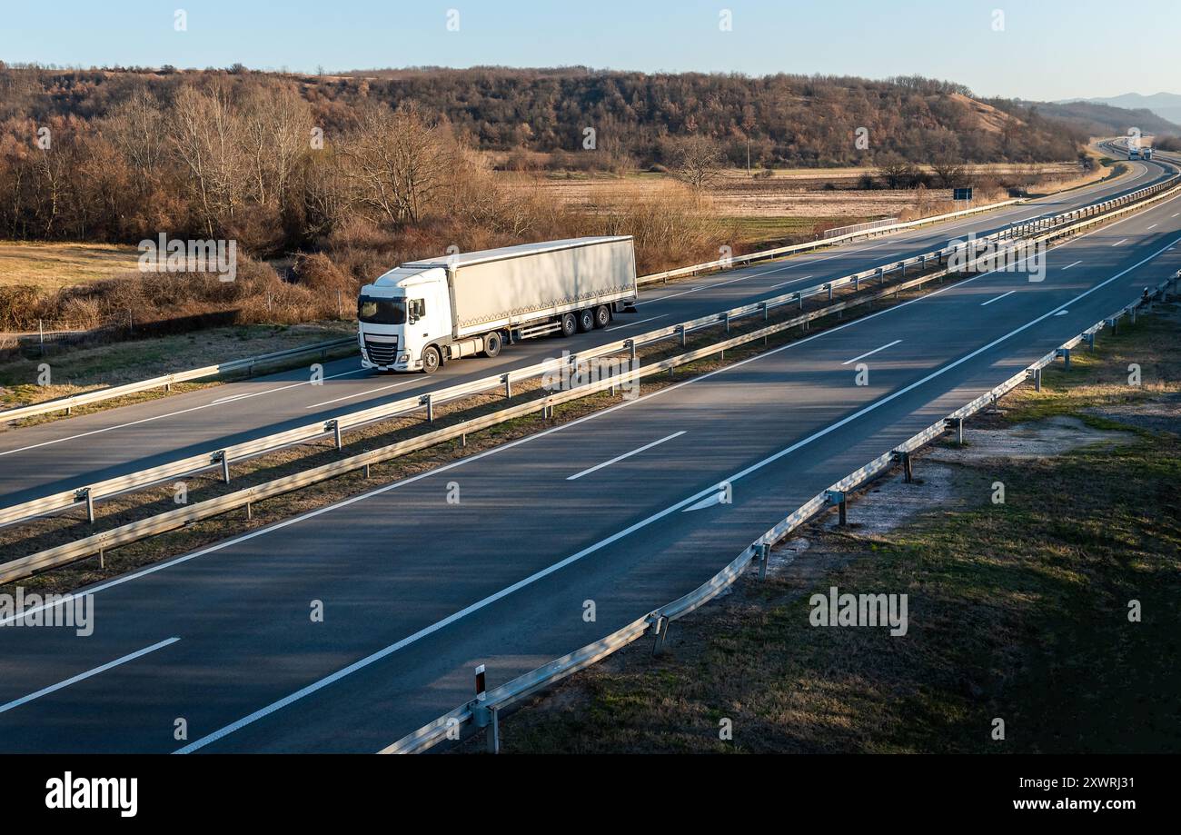 Highway transportation scene with white transportation truck on a rural ...