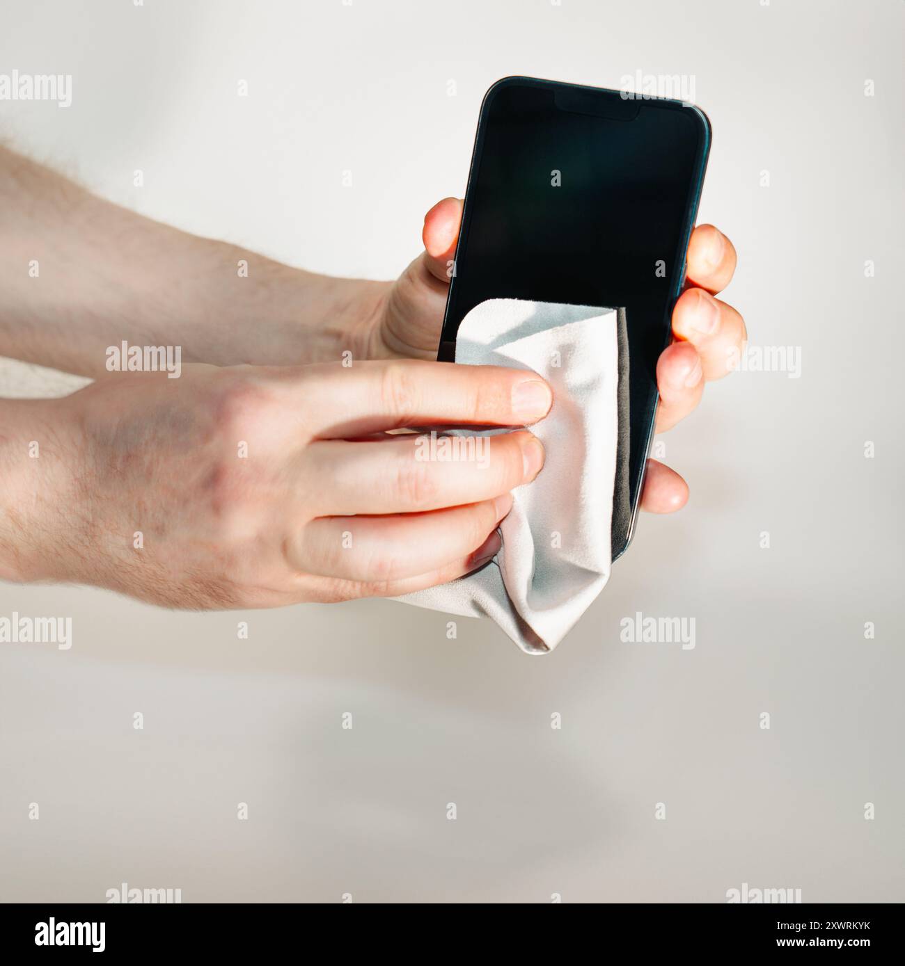 hand wiping smart phone screen with cloth. White background Stock Photo ...