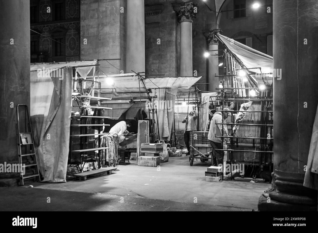 B&W. Street vendors clearing their stalls, as every evening, under the ...