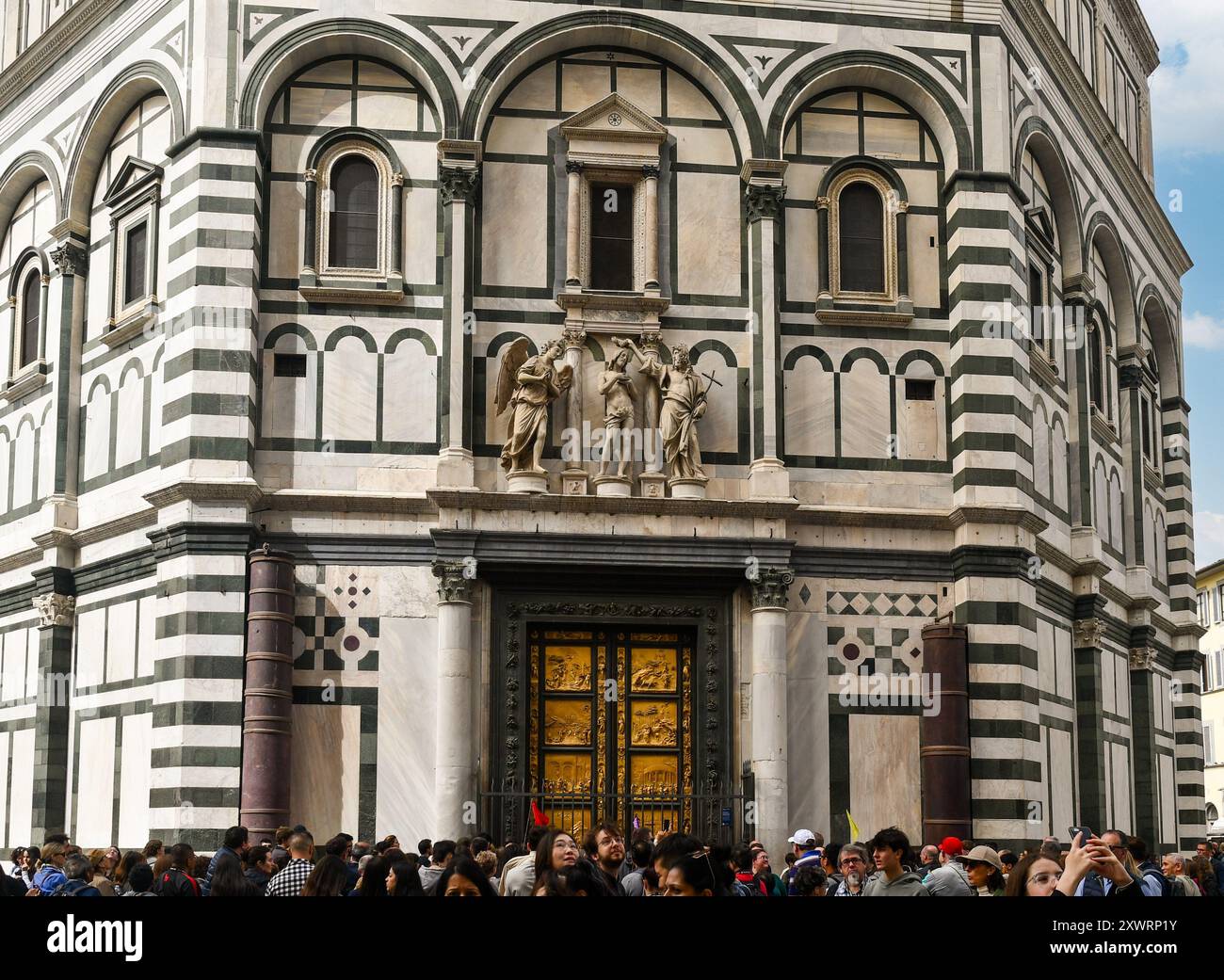 Crowd of tourists admiring the famous golden bronze Gate of Paradise at ...