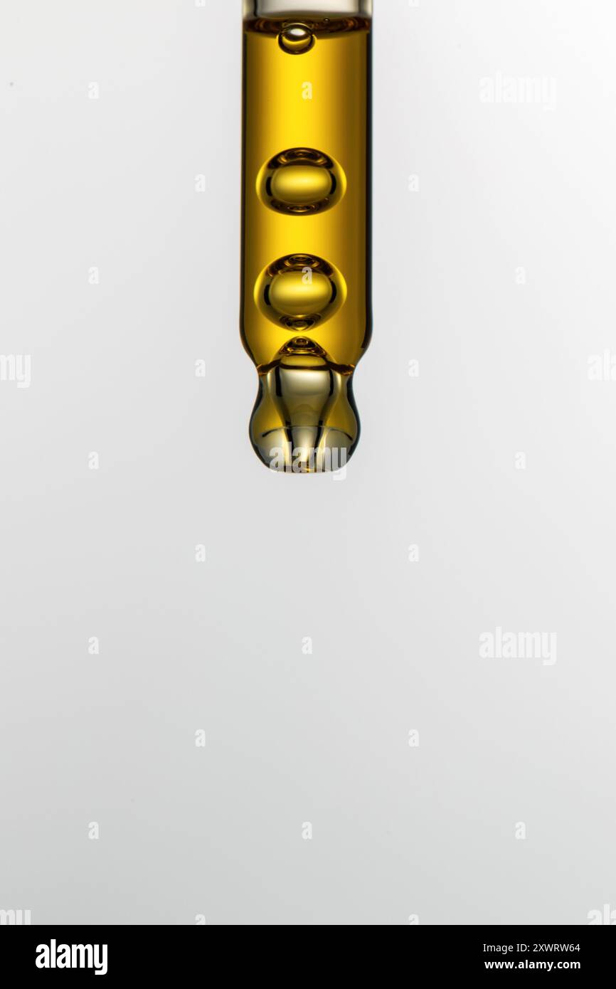 Dripping cosmetic serum from pipette on white background. Face serum ...