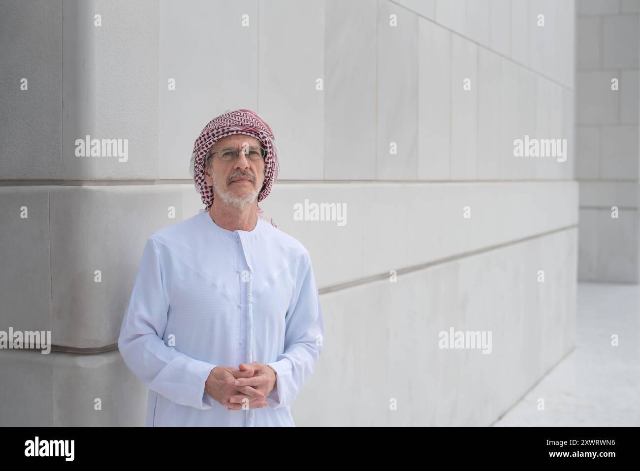 Elderly Arab man stands confidently wearing traditional kandora attire ...
