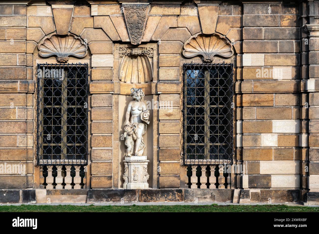 Two rectangular windows against a stone wall and a white sculpture on a ...