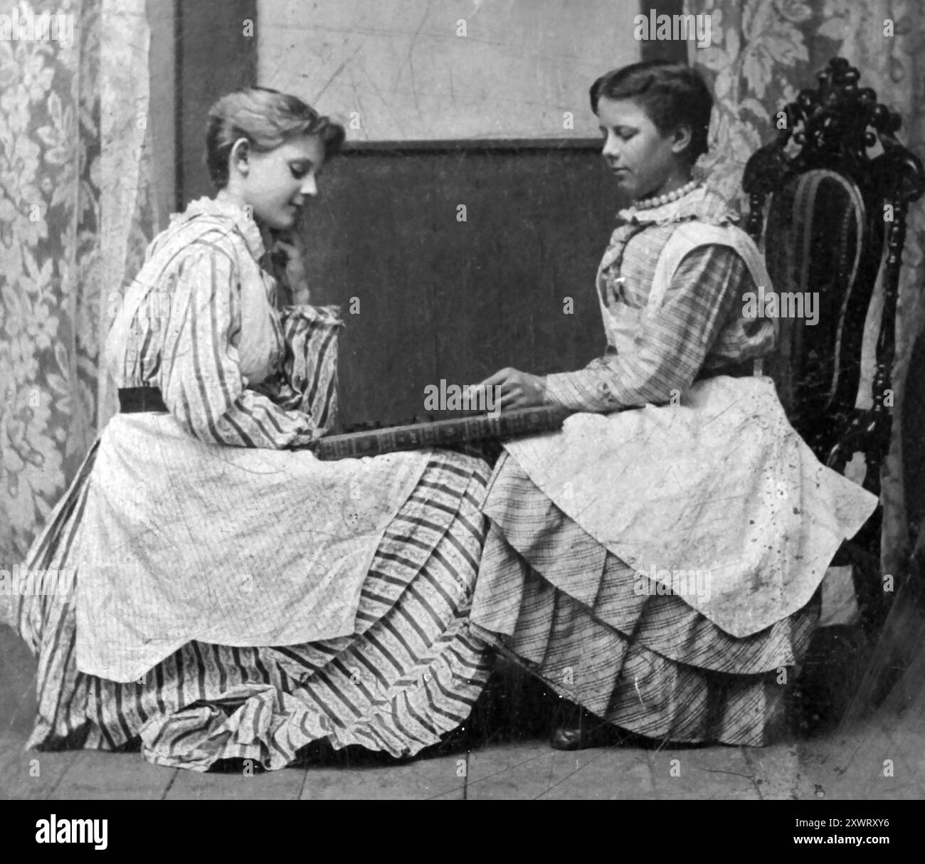 Teenage sisters play a board on their laps, ca. 1895 Stock Photo - Alamy