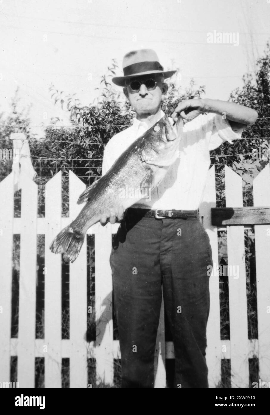 Senior man with a large fish in the backyard, ca. 1940 Stock Photo - Alamy