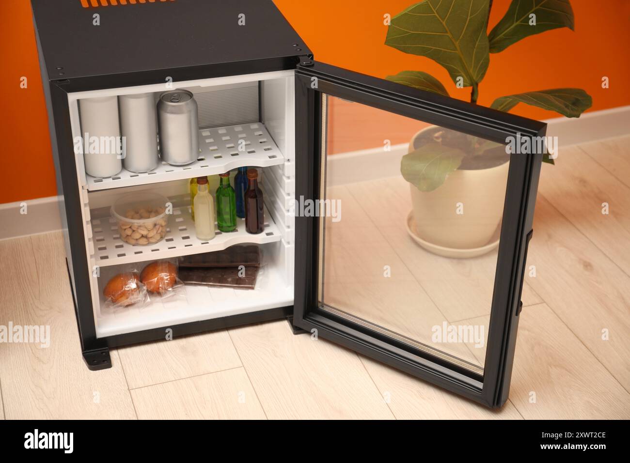 Mini refrigerator with different drinks and snacks indoors Stock Photo ...