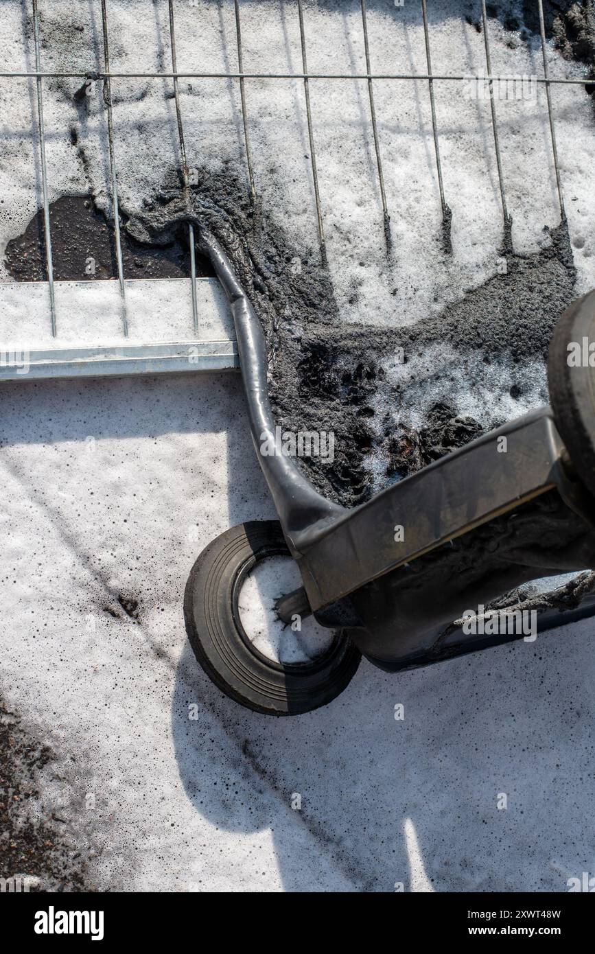 Close-up of a burnt trash bin covered with extinguishing foam. This ...