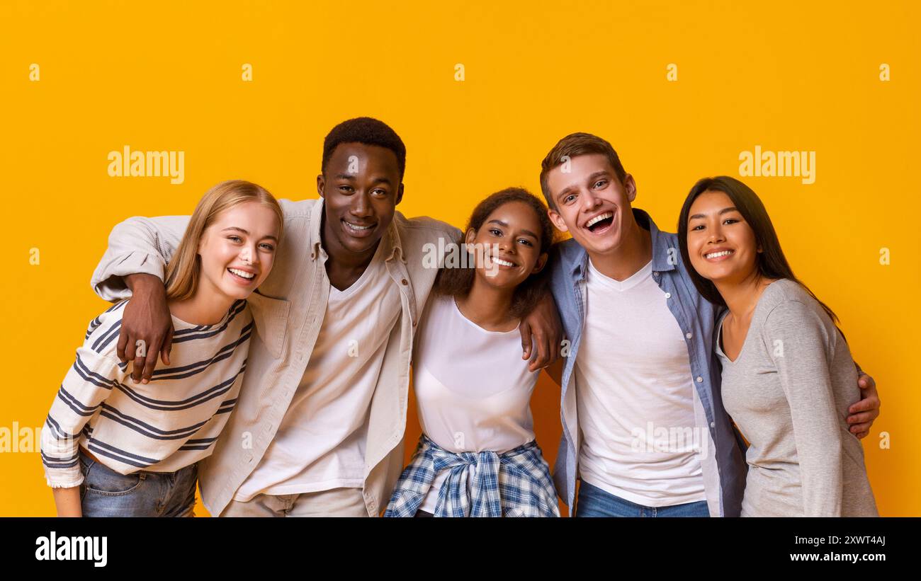 Friendly group of international students smiling over yellow background ...