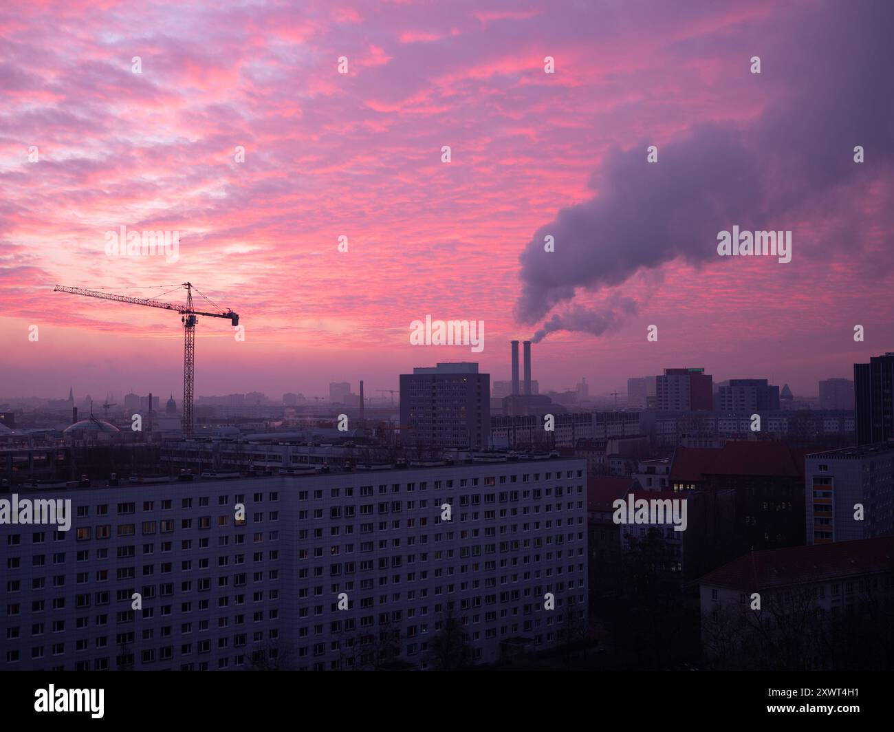 A beautiful dawn in Berlin with a pink sky, industrial smokestack, and ...