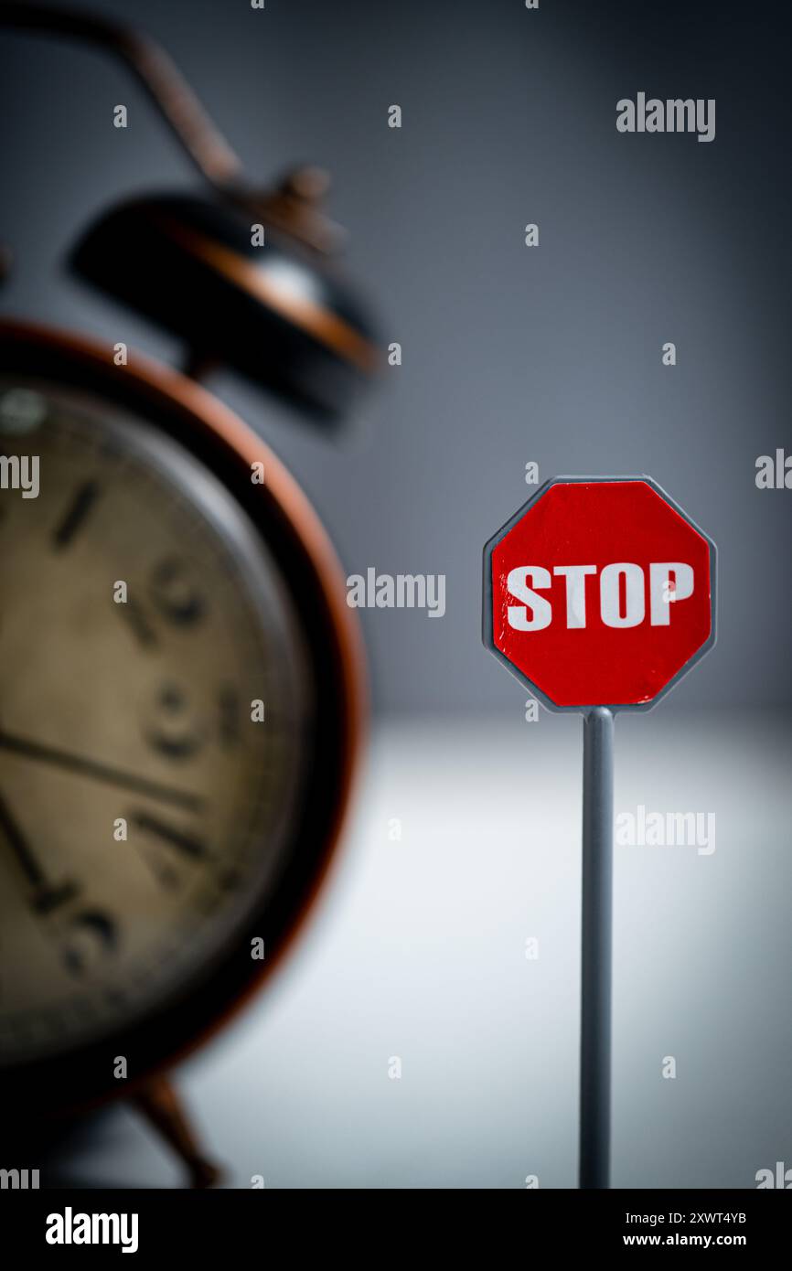 Stop sign and alarm clock on a dark background. Selective focus Stock ...