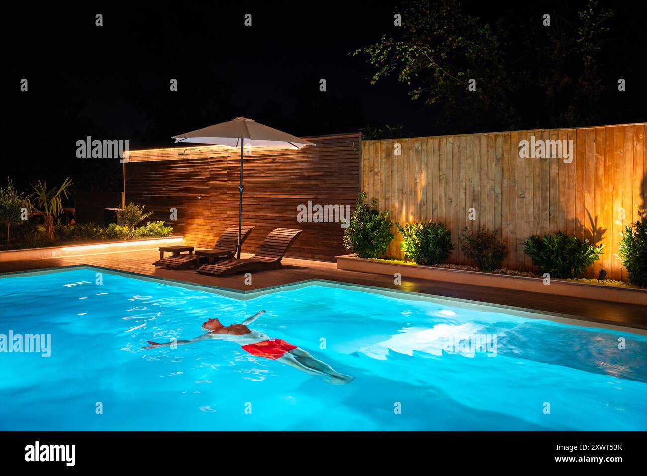 Man swimming alone in the luxury villa swimming pool at night Stock ...