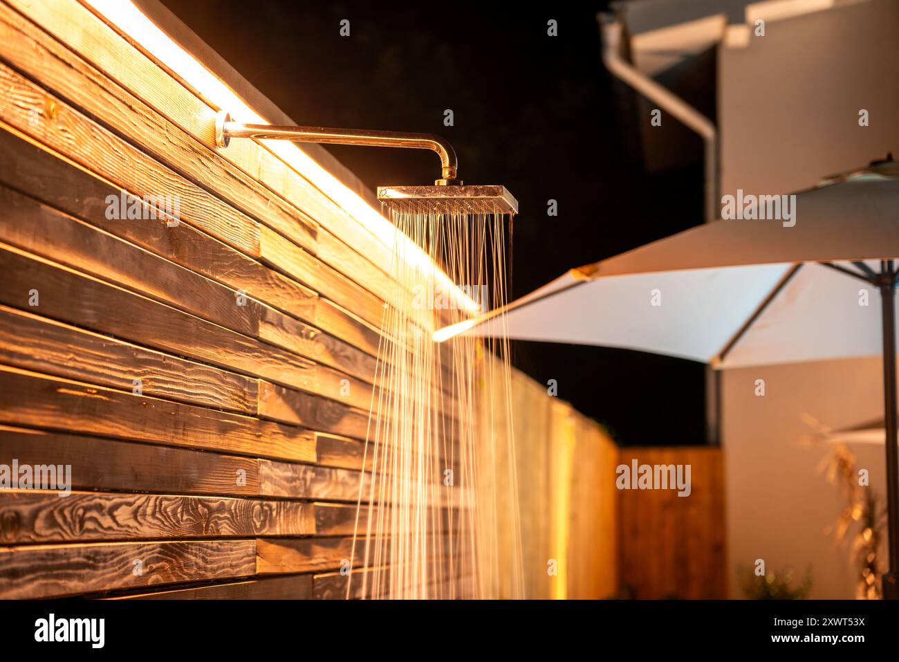 Outdoor shower with flowing water at night near swimming pool. Concept ...