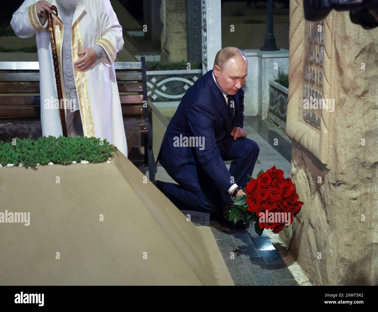 Russian President Vladimir Putin places flowers at the grave of the ...