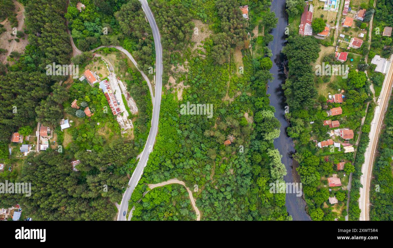 Aerial view of winding road trough the dense woods on the high mountain ...