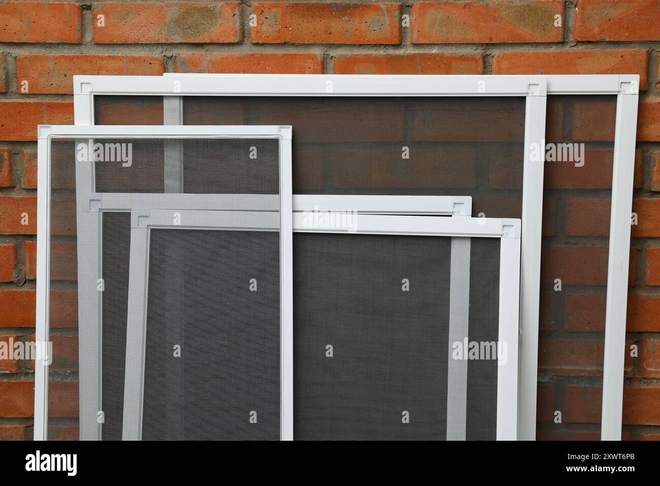 Set of window screens near brick wall Stock Photo - Alamy