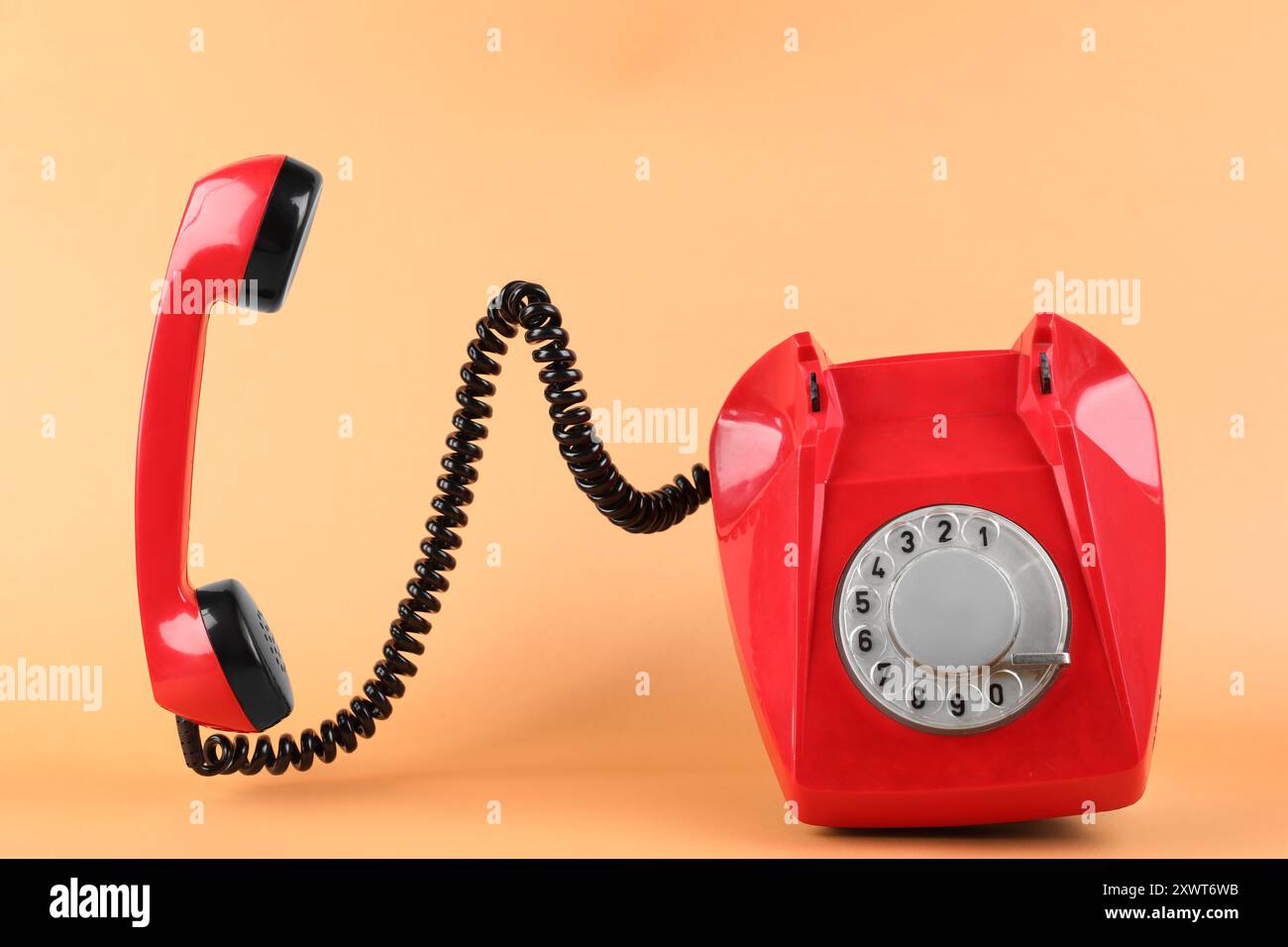 One red telephone with handset on pale orange background Stock Photo ...