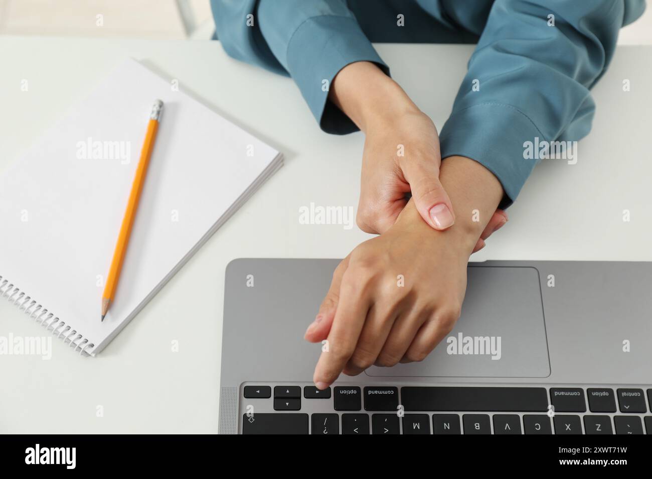 Carpal tunnel syndrome. Woman suffering from pain in wrist at desk ...