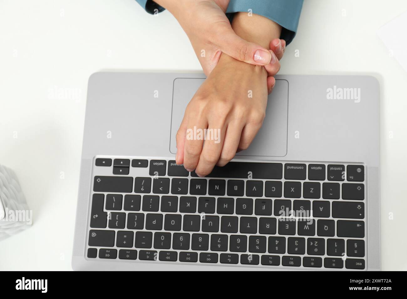 Carpal tunnel syndrome. Woman suffering from pain in wrist at desk, top ...
