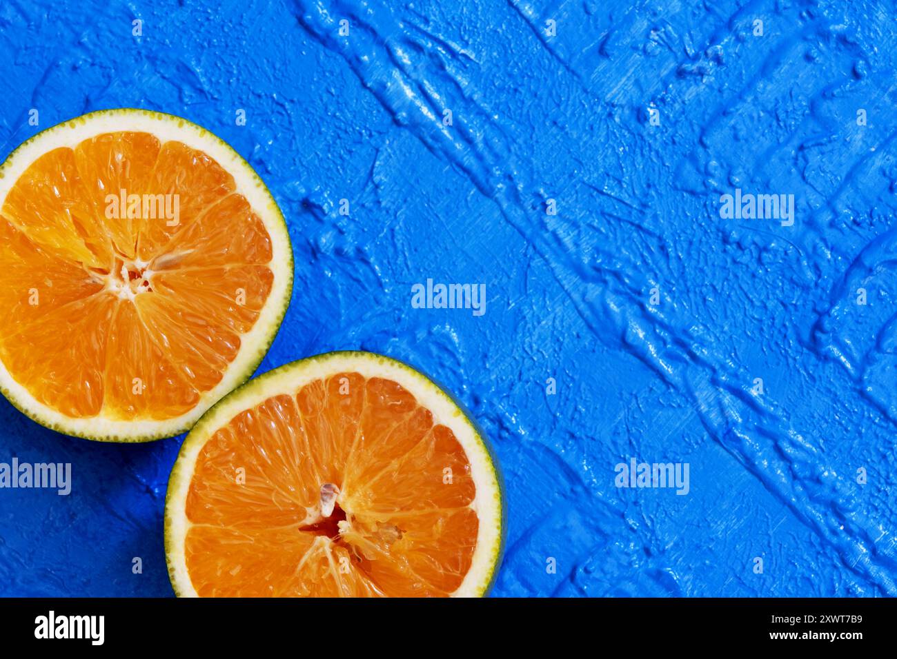 Two parts of an orange in a diagonal position in the lower left corner ...