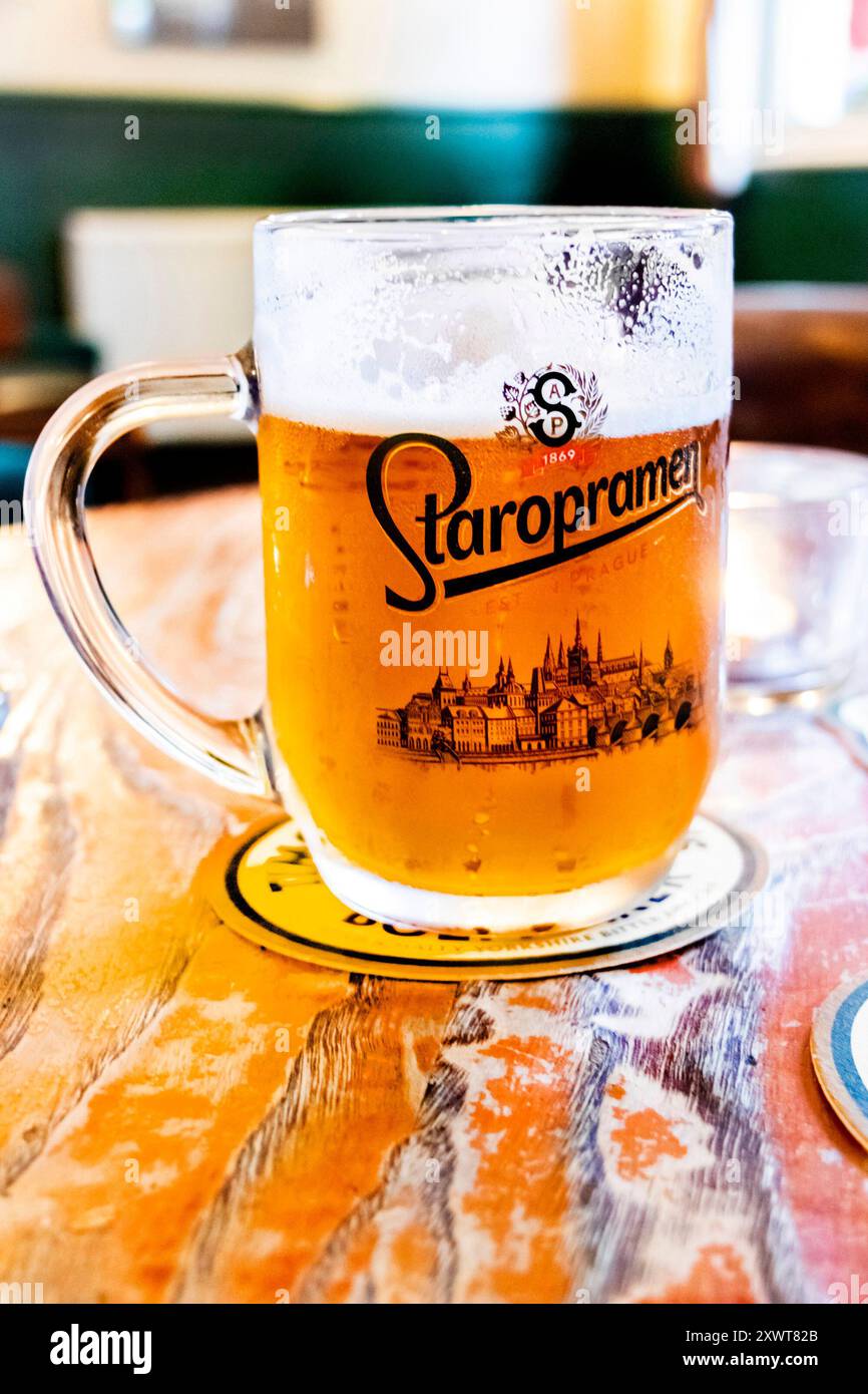 pint glass on wooden table of staropramen lager beer in british pub uk ...