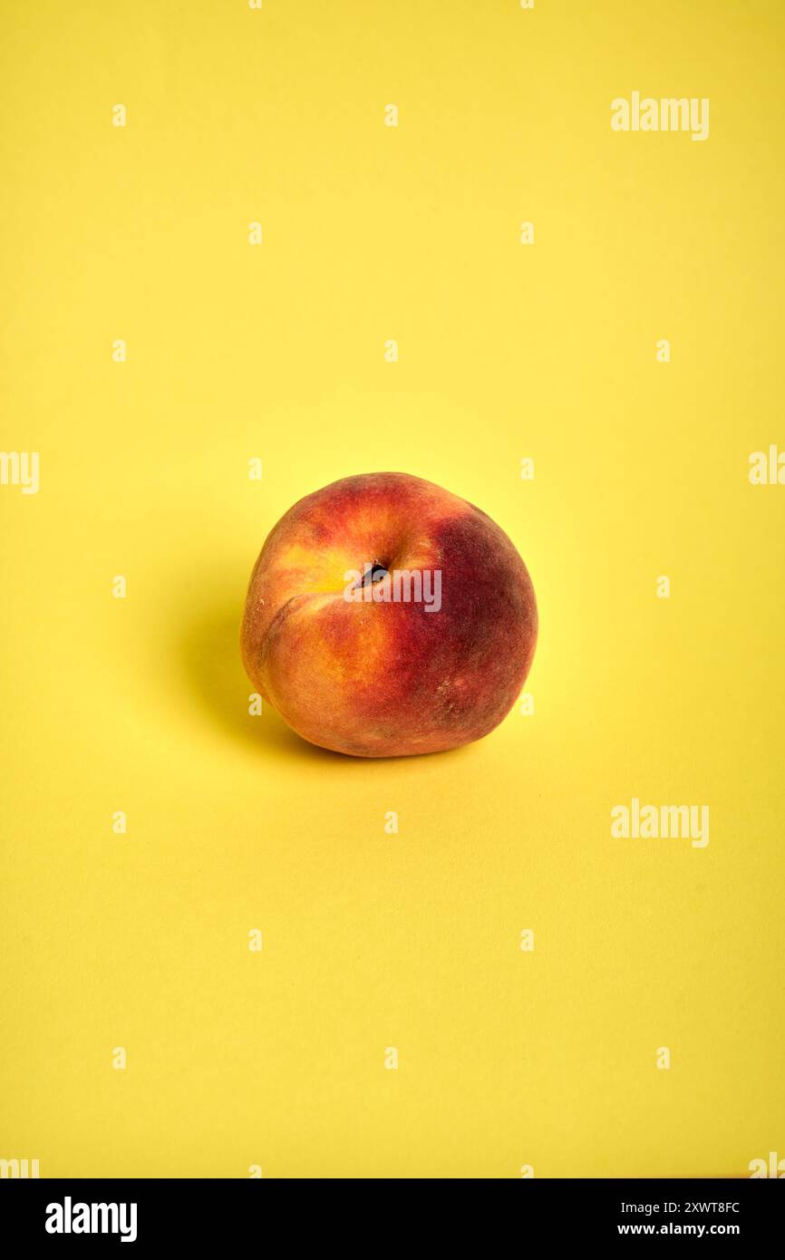 Peach on yellow background isolated Stock Photo - Alamy