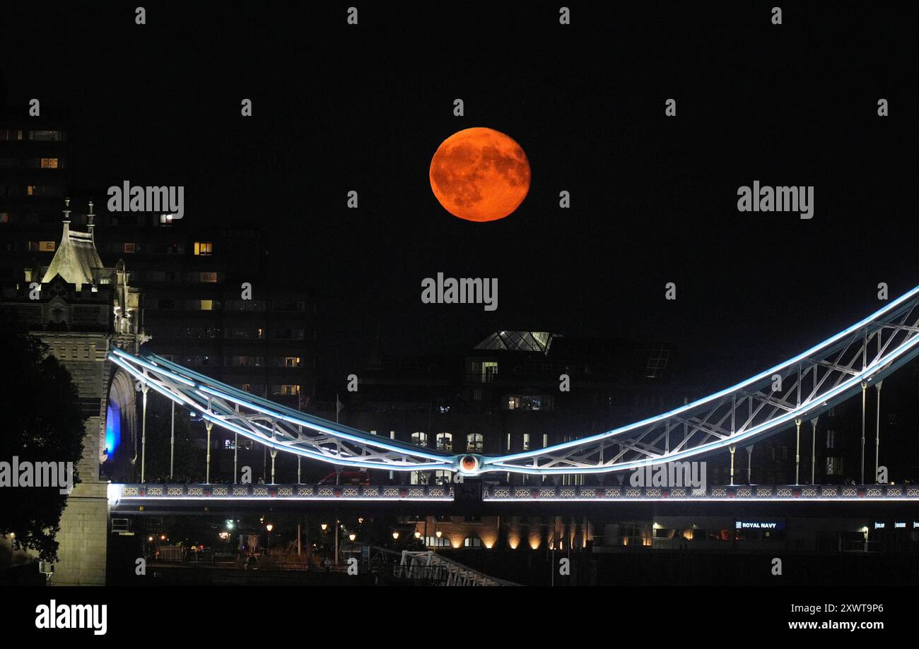 A waning gibbous moon rises over Tower Bridge in London. Picture date ...
