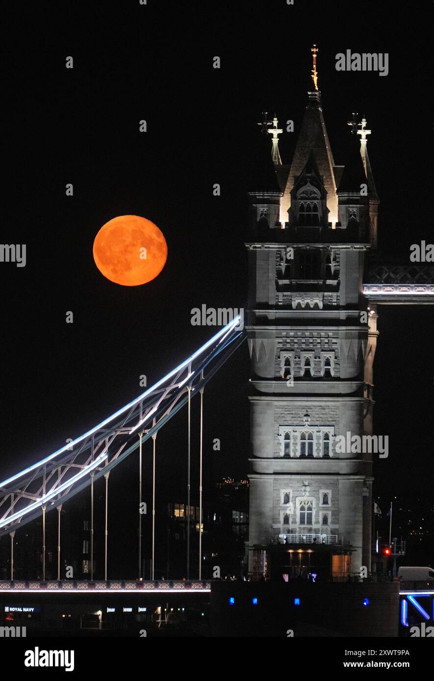 A waning gibbous moon rises over Tower Bridge in London. Picture date ...