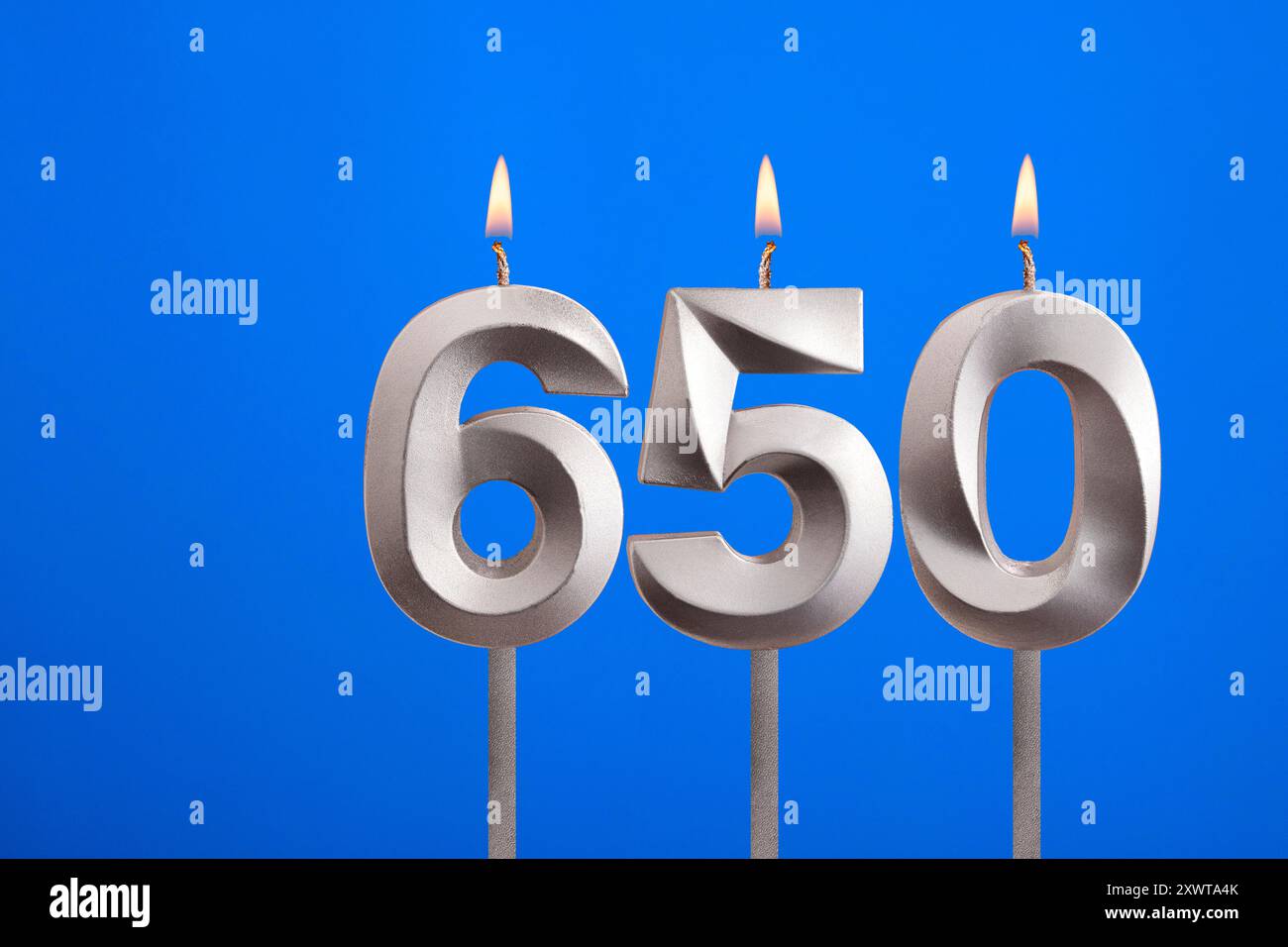 Birthday number 650 - Candle lit on blue background Stock Photo - Alamy