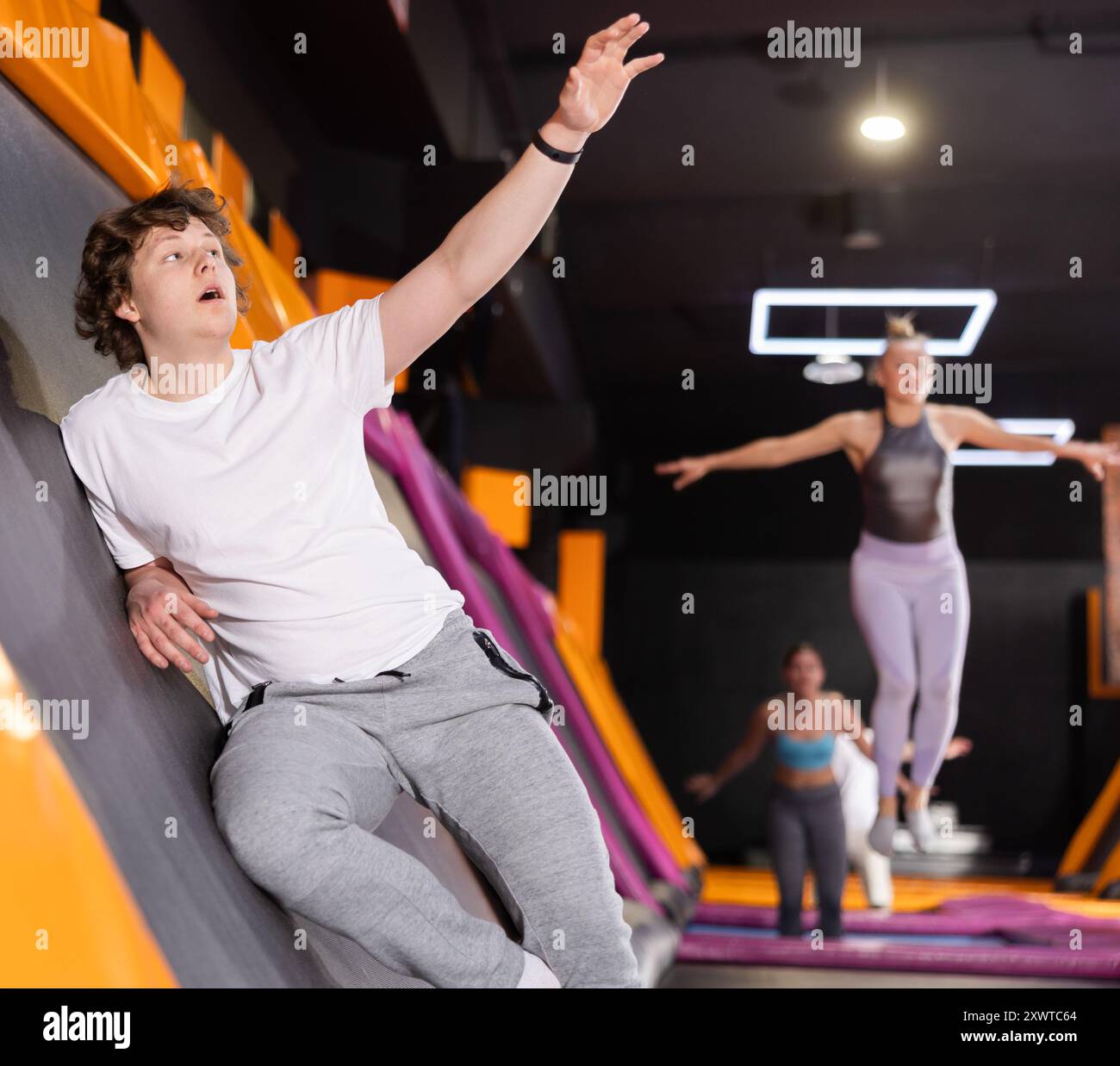 Teenage boy in sport clothes high jumping in trampoline arena Stock ...