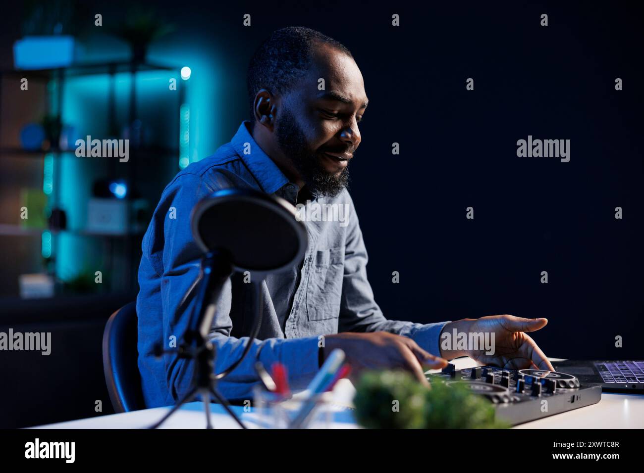 Artist filming DJ mixing tutorial in apartment studio, showing examples ...