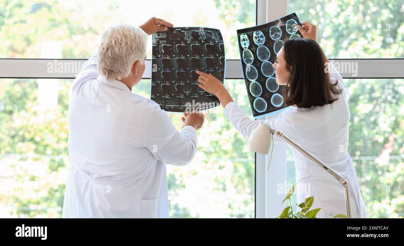 Doctors examining x-ray scans in medical office near window Stock Photo ...
