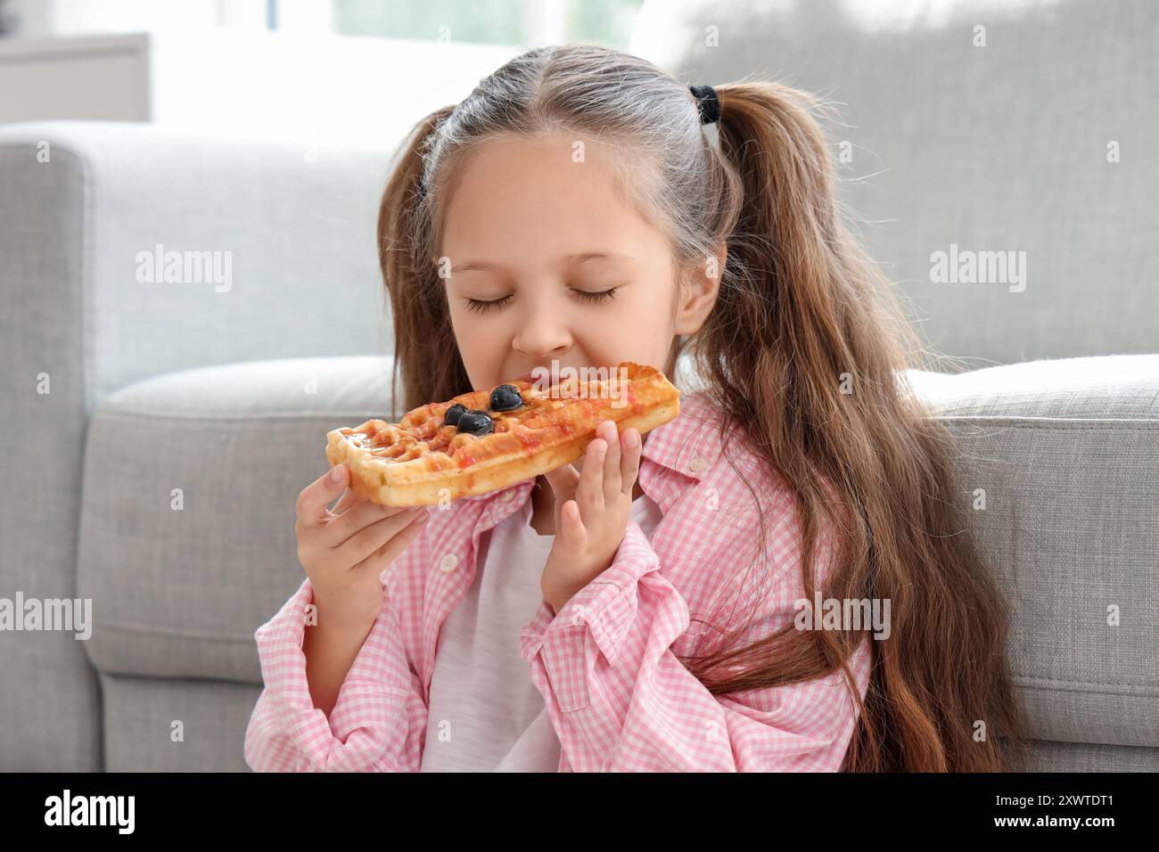 Cute little girl eating waffle with honey at home, closeup Stock Photo ...