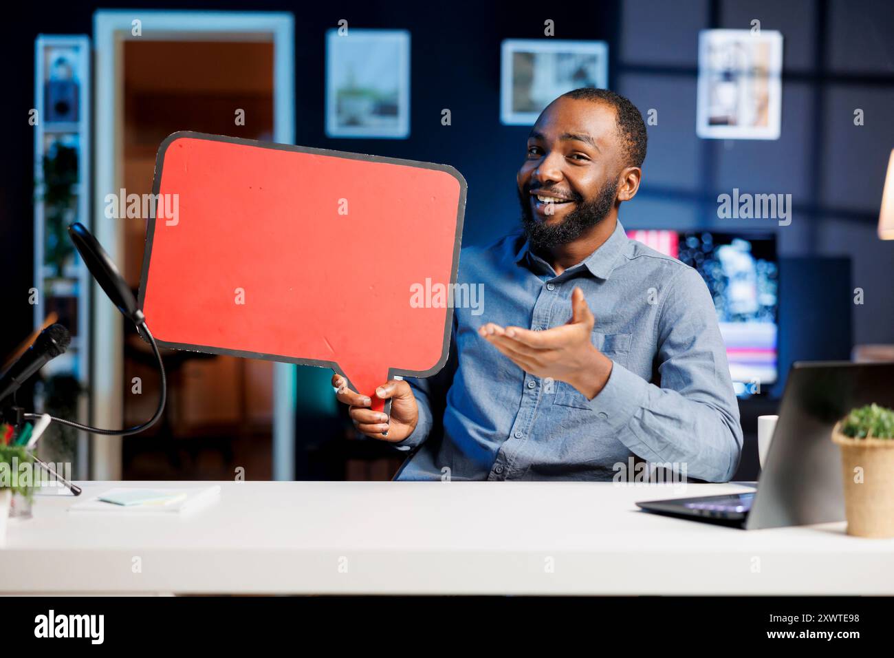 Happy man filming sponsored content, holding empty copy space sign in ...