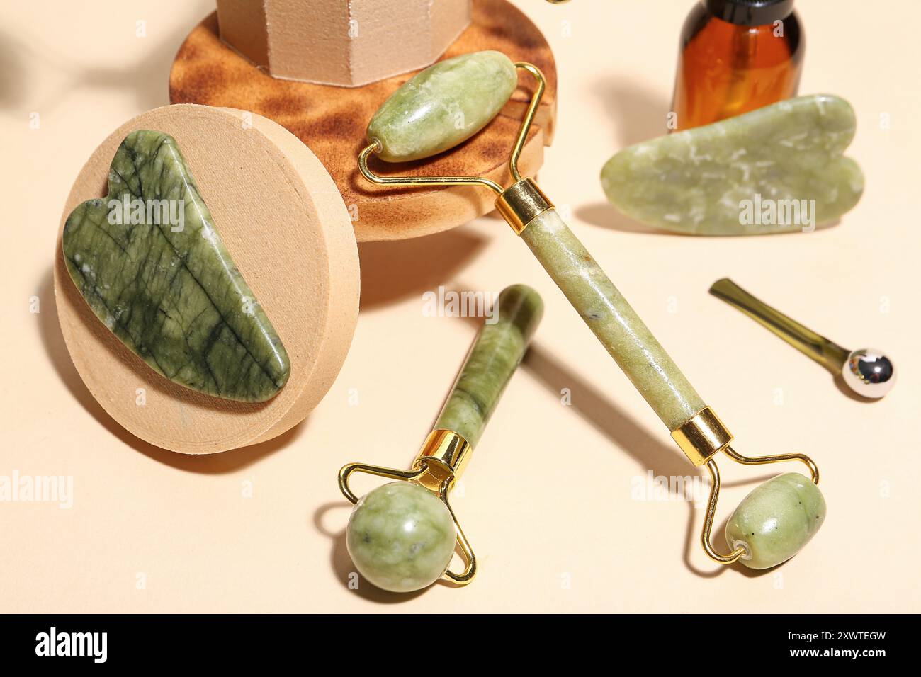 Facial massage tools and plaster stands on beige background, closeup ...
