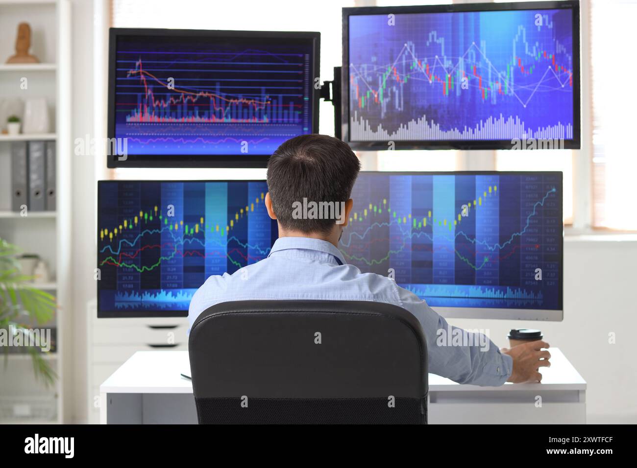 Male trader working at table in office, back view Stock Photo - Alamy