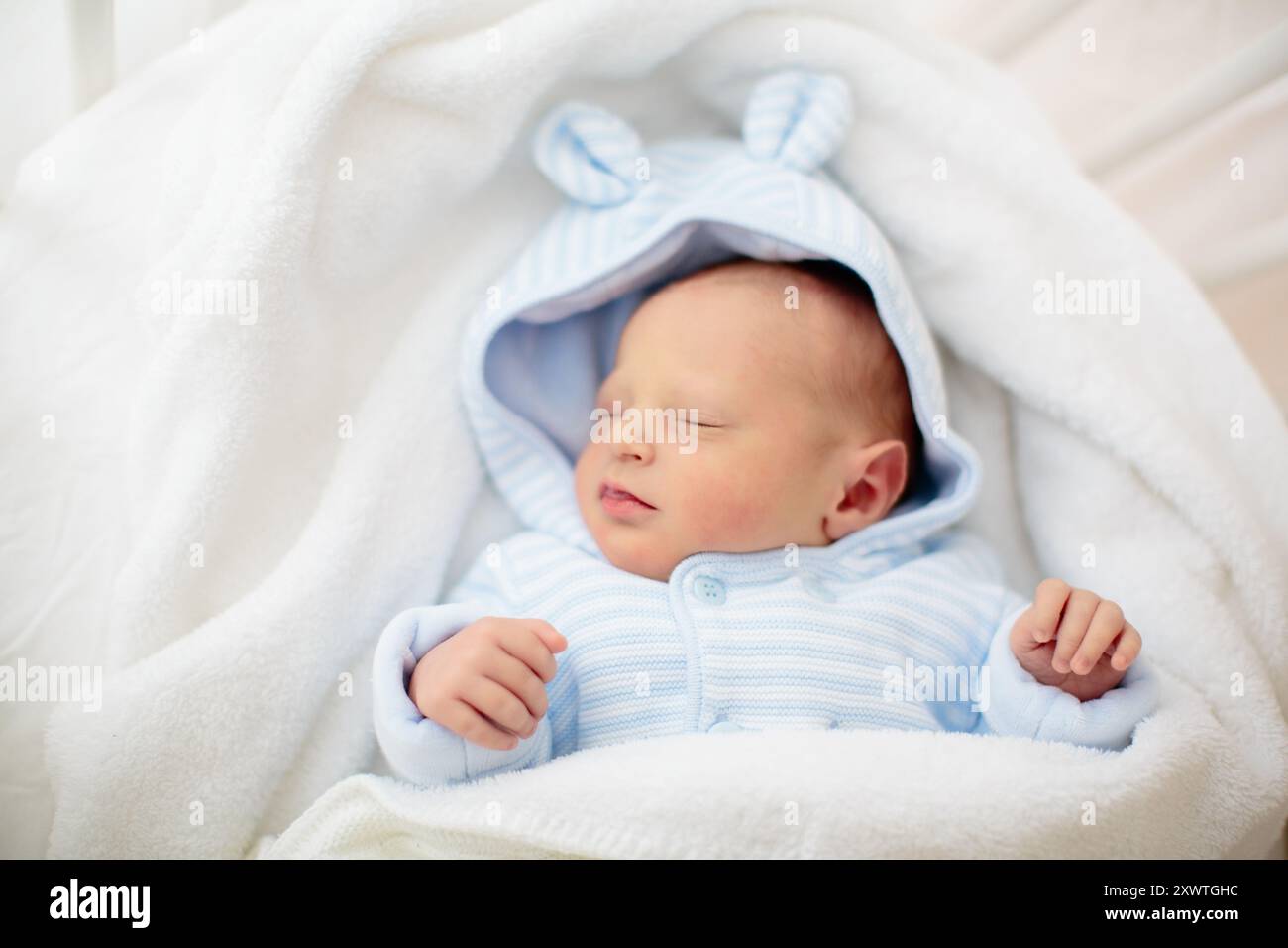 Newborn baby in hospital room. New born child in wooden co-sleeper crib ...