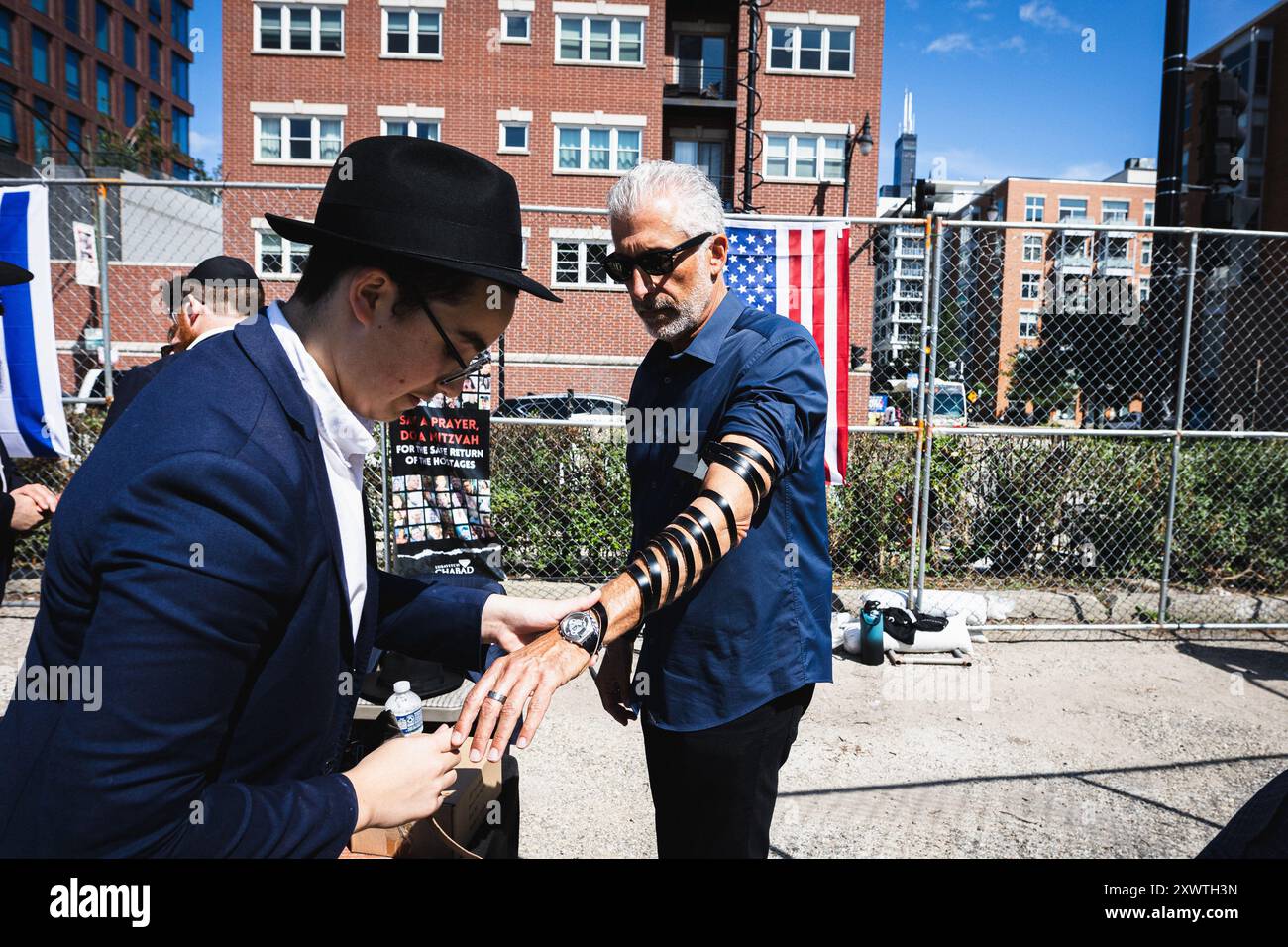 Chicago, Illinois, USA. 20th Aug, 2024. Visitors engage in the ritual of Tefillin and prayer as ...