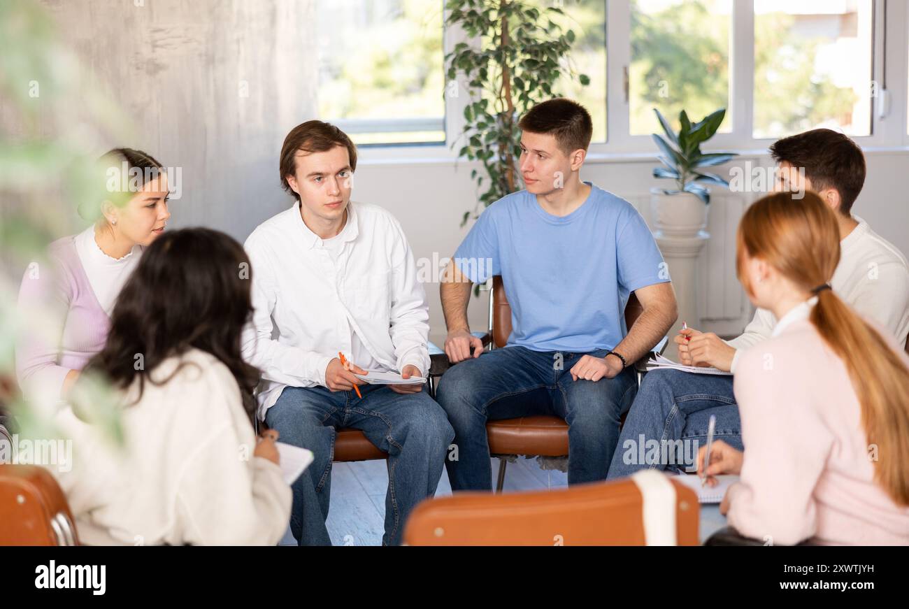 Group of students engaged in discussion in classroom Stock Photo - Alamy