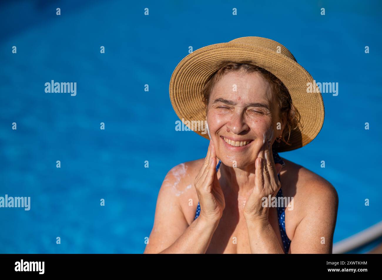 Woman applying sunscreen pool enjoying hi-res stock photography and ...