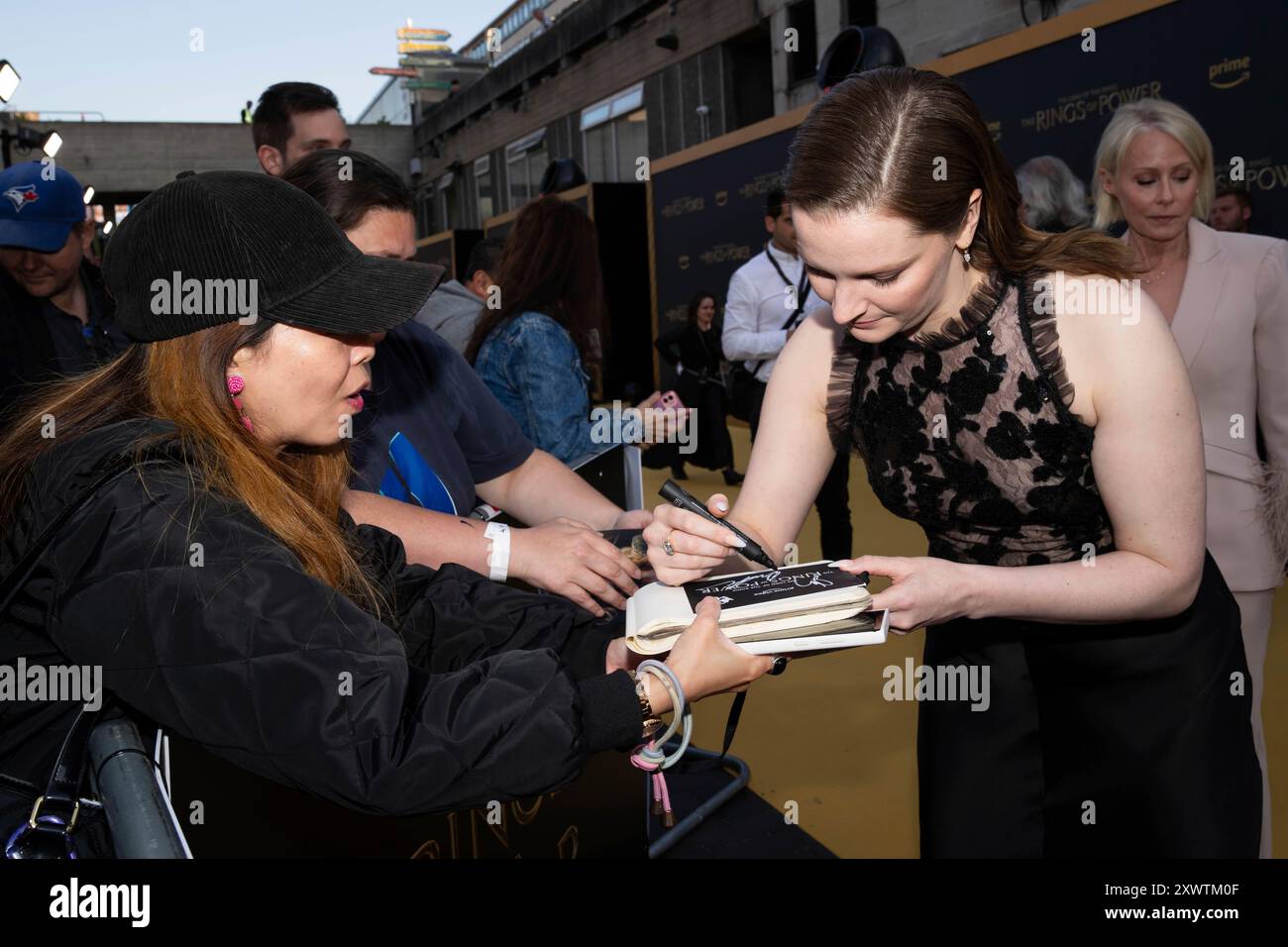 Morfydd Clark signs an autograph for a fan at the World Premiere for ...