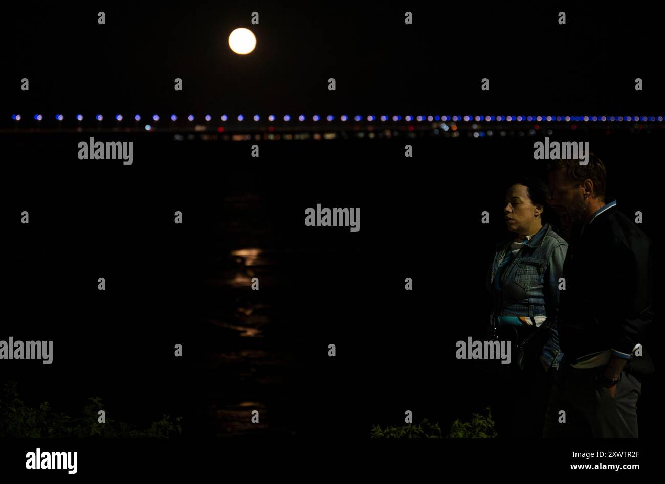 People observe the blue moon phenomenon from one of the walkways near ...