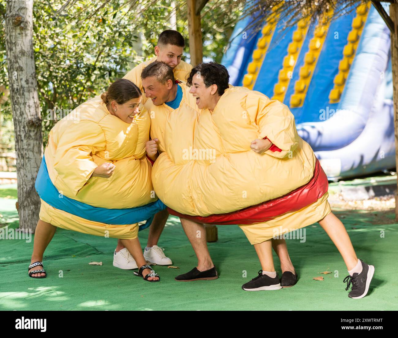 Men and women in large sumo suits having fun in adventure park Stock ...