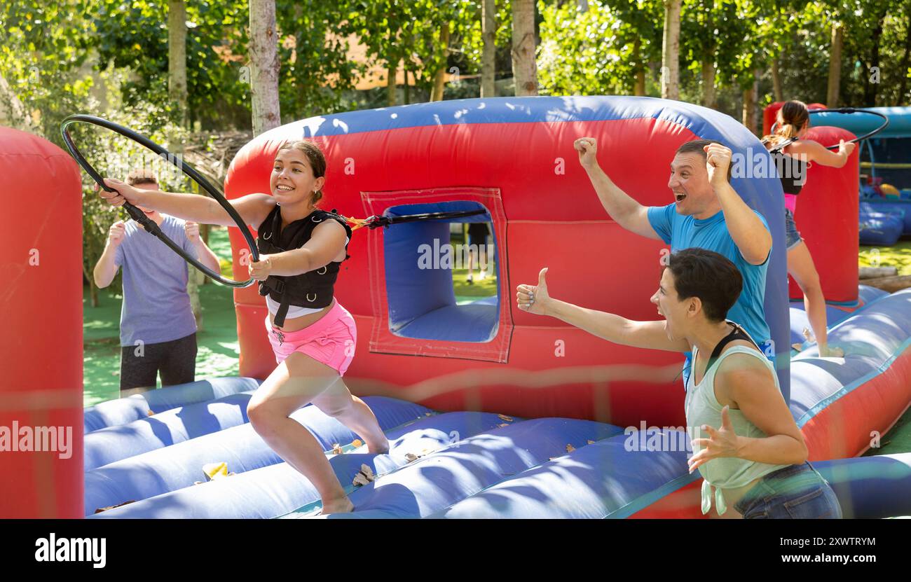 Girl playing tug of war game with hoop on playground in amusement park ...