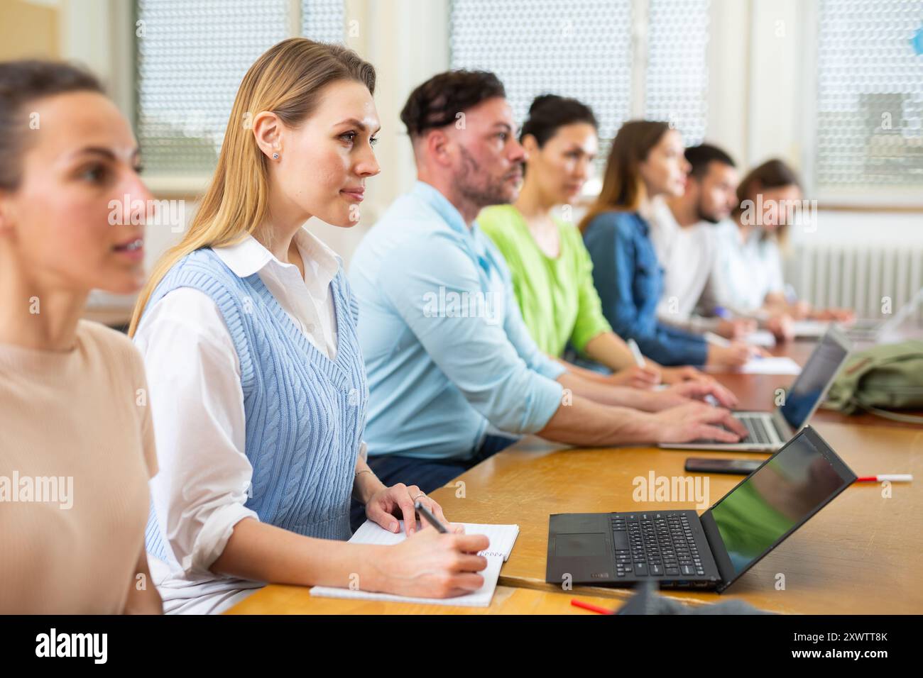 Female student writing during lecture in class room Stock Photo - Alamy