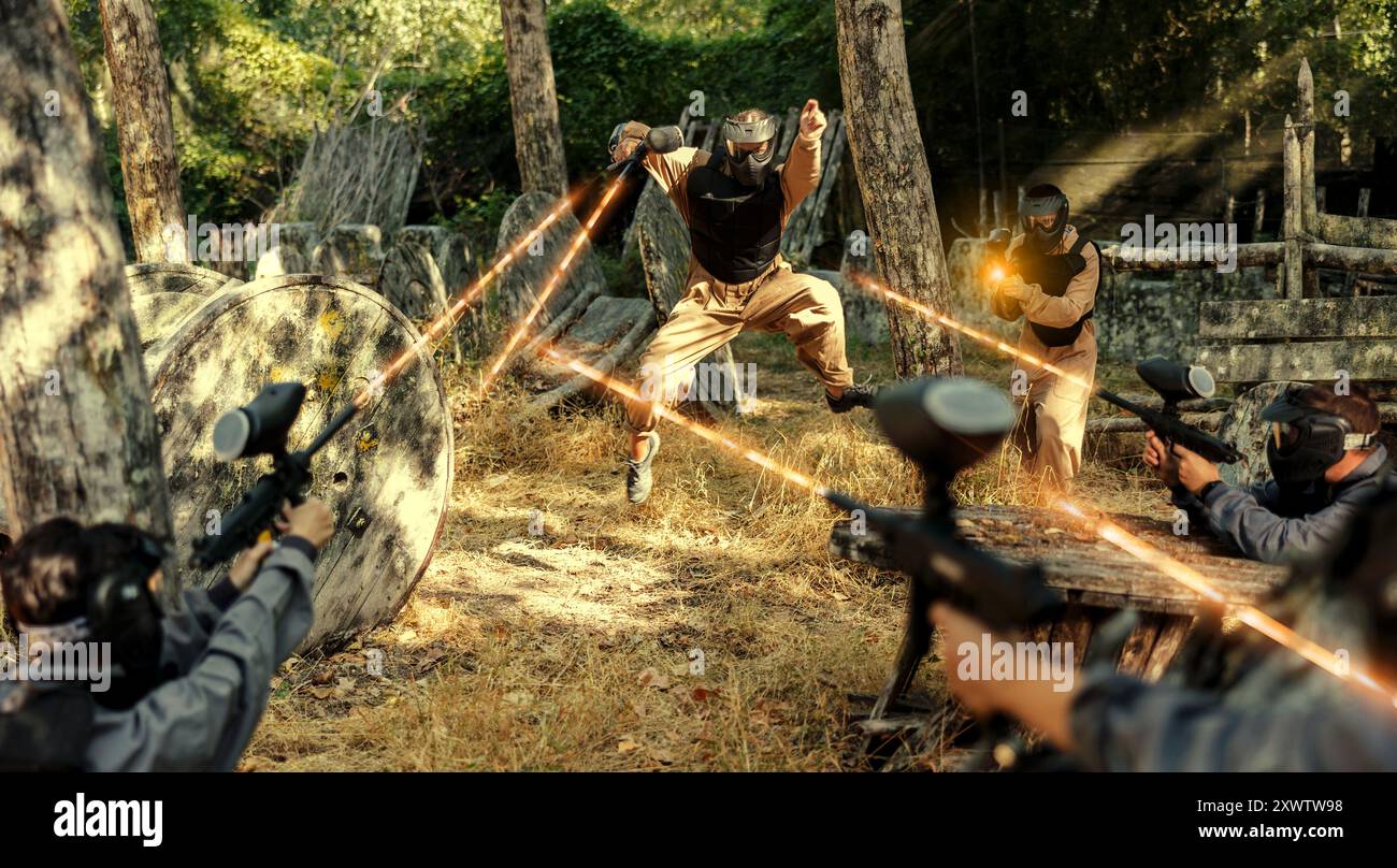 Group of people in full gear playing paintball on shooting range ...