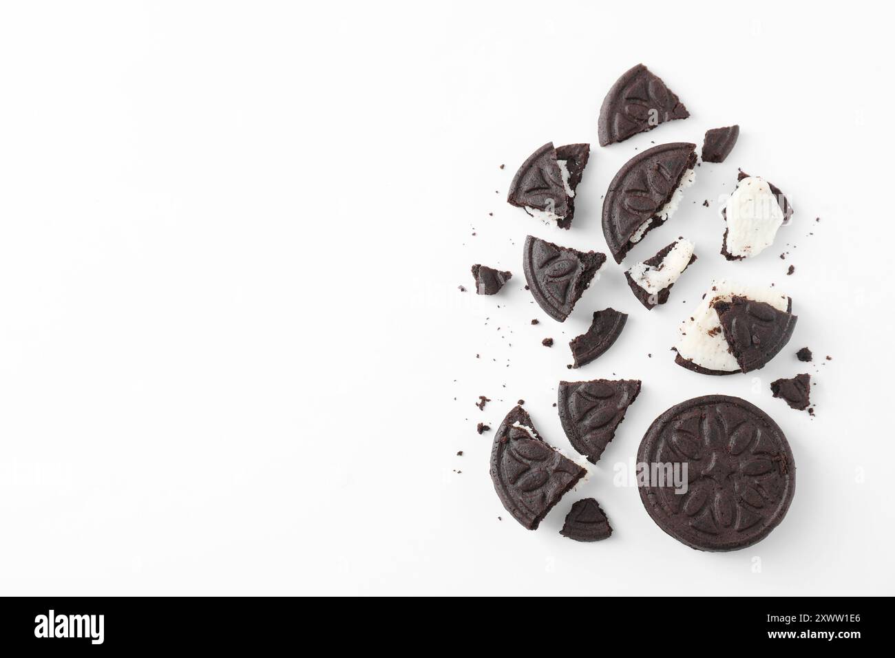 Whole and broken tasty sandwich cookies on white background, flat lay ...